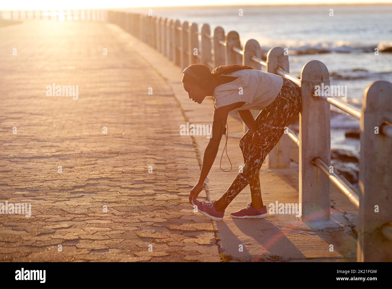 Its important to stretch out those muscles. a young woman stretching ...