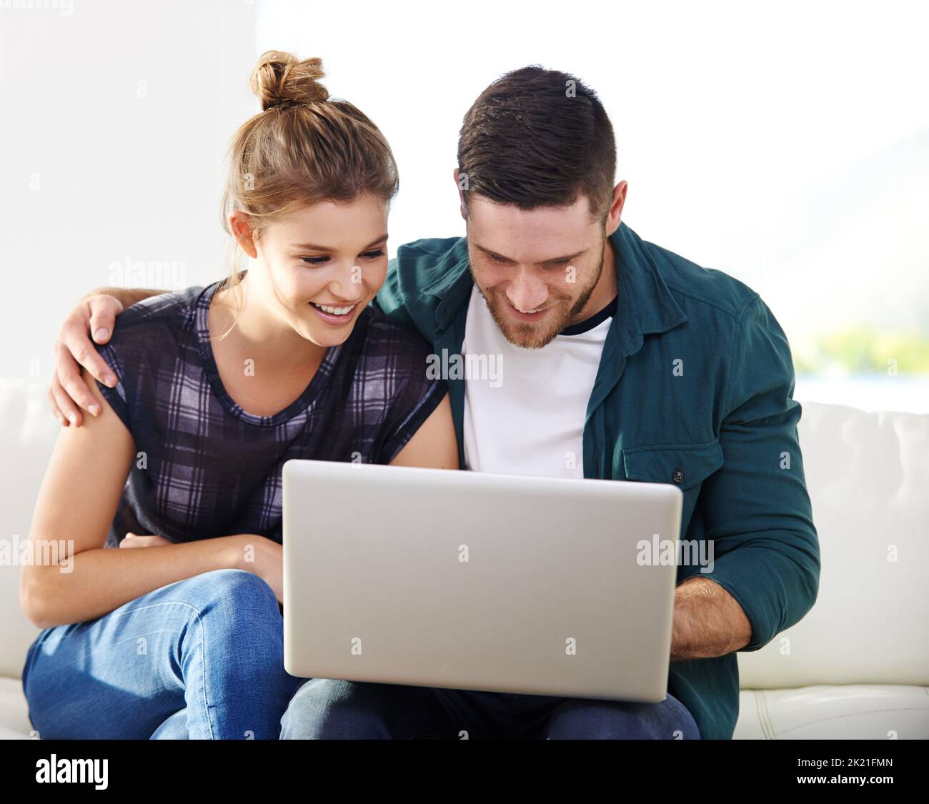 The modern couple. a happy young couple using a laptop while relaxing ...
