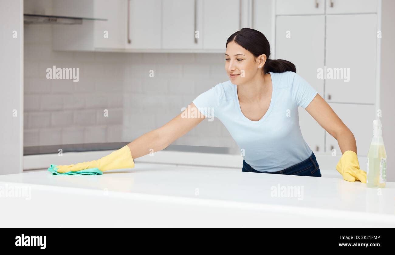 Woman, wipe or cleaning kitchen counter with housekeeping spray bottle ...