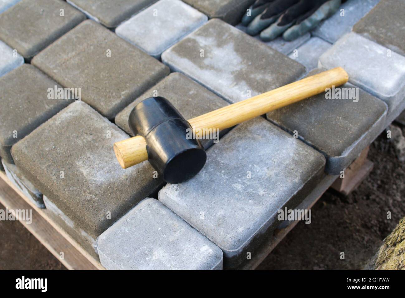 Defocus paving hammer. Stack of paving stones. Garden brick pathway ...