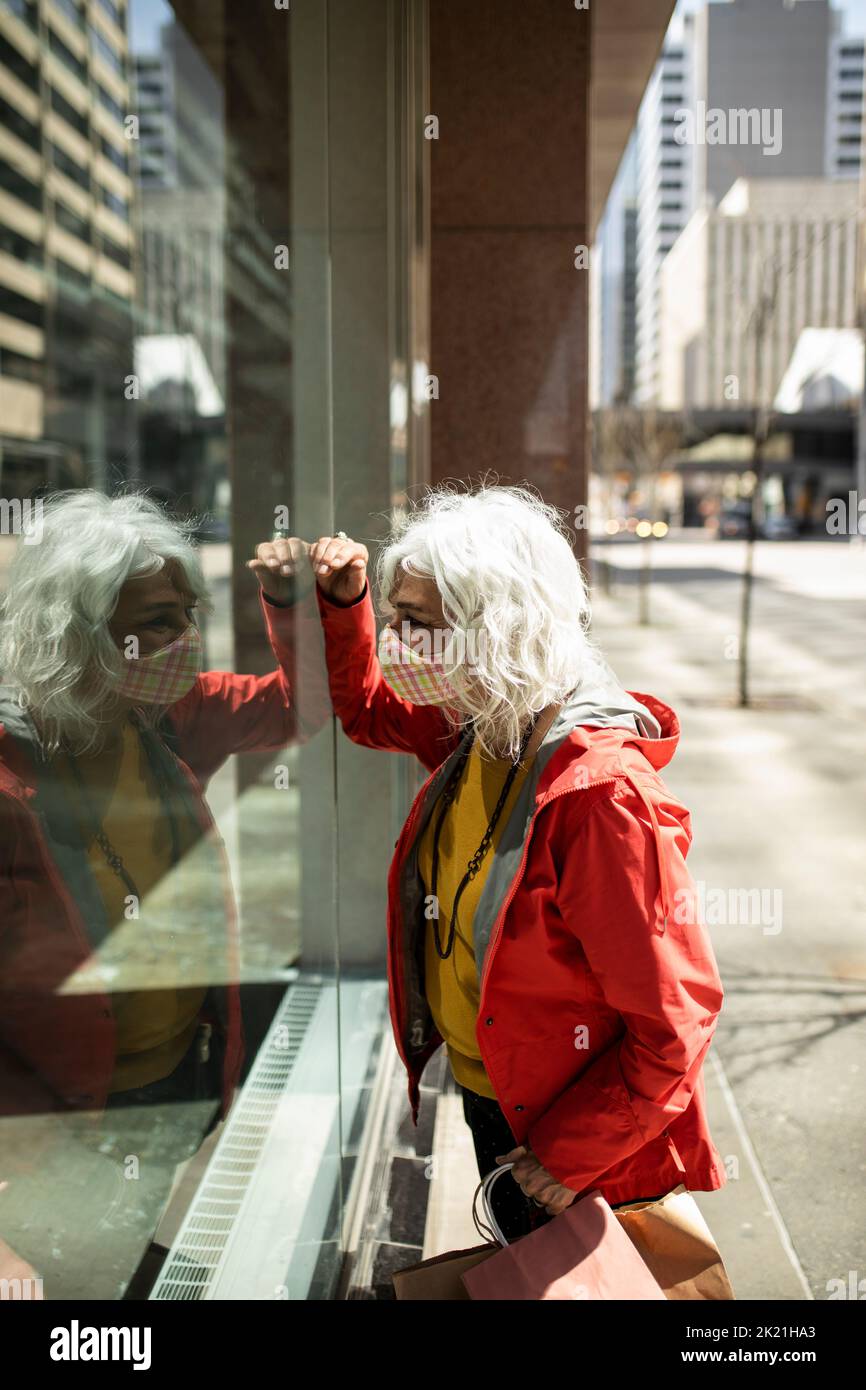Woman looking at reflection in window hi-res stock photography and ...