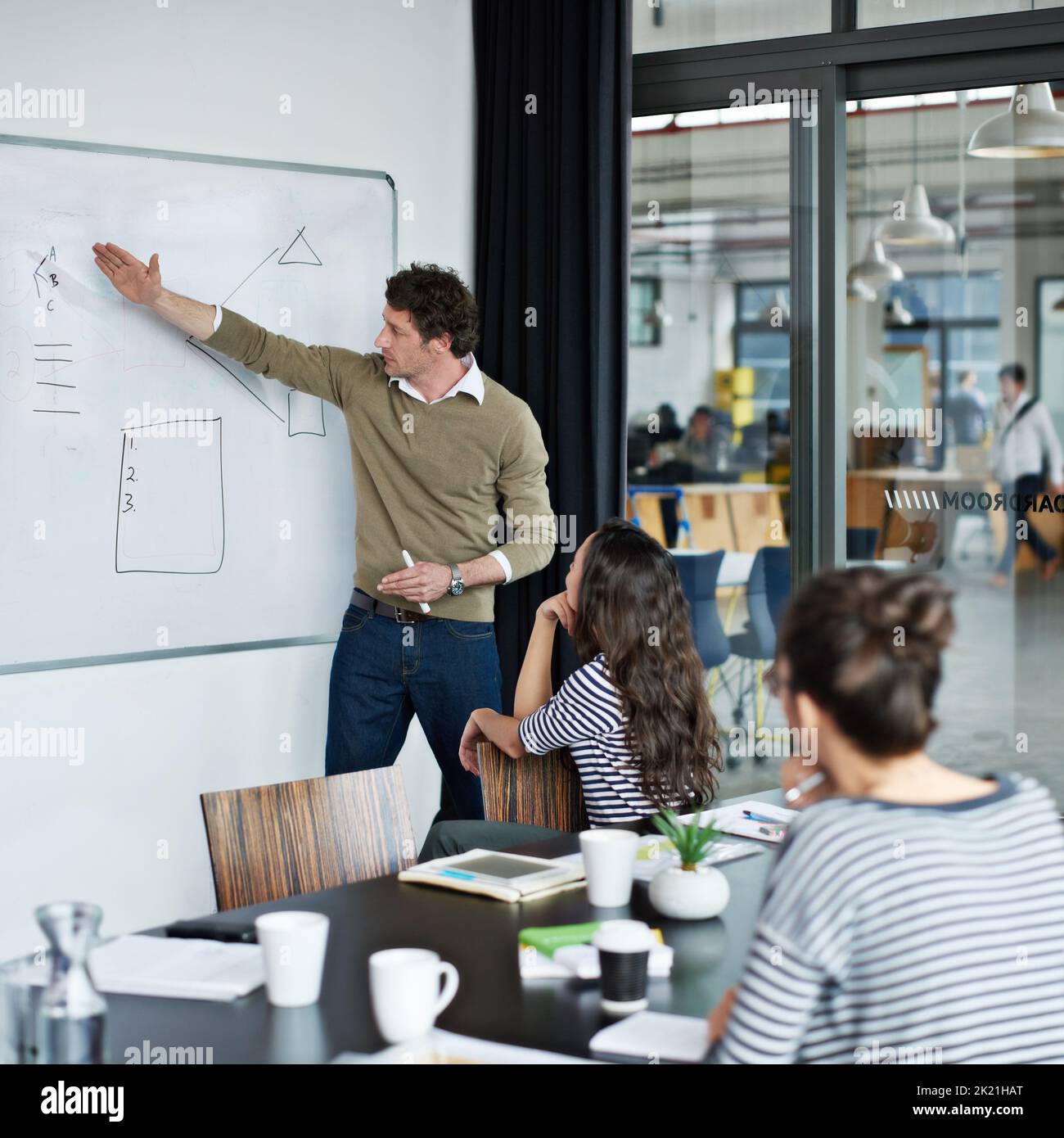 Demonstrating his vision to the group. a group of colleagues watching a ...