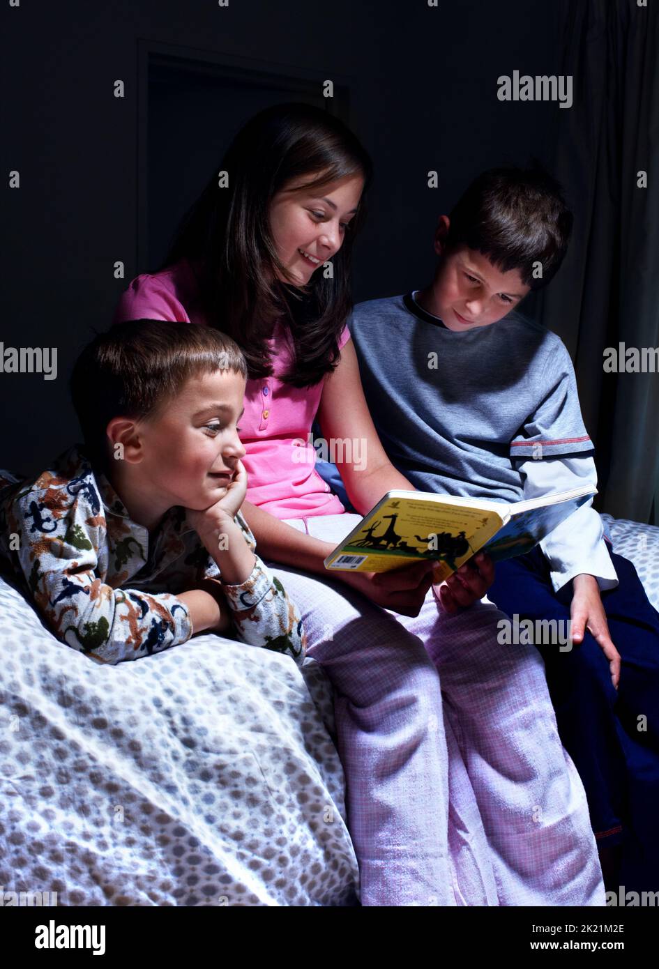 Getting caught up in the wonderful story. A sister reading to her ...