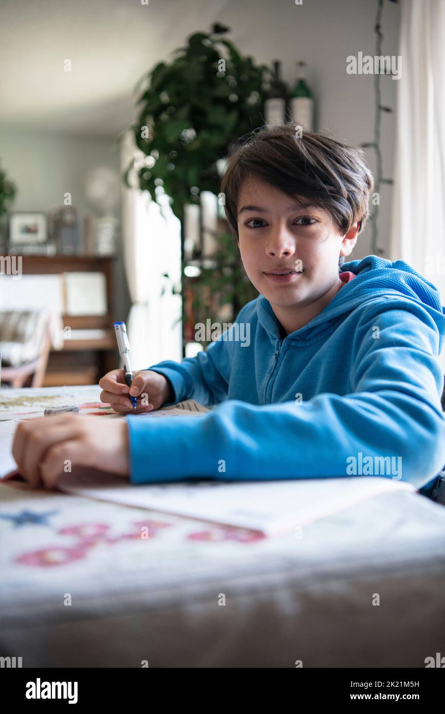 Portrait confident boy doing homework at dining table Stock Photo - Alamy