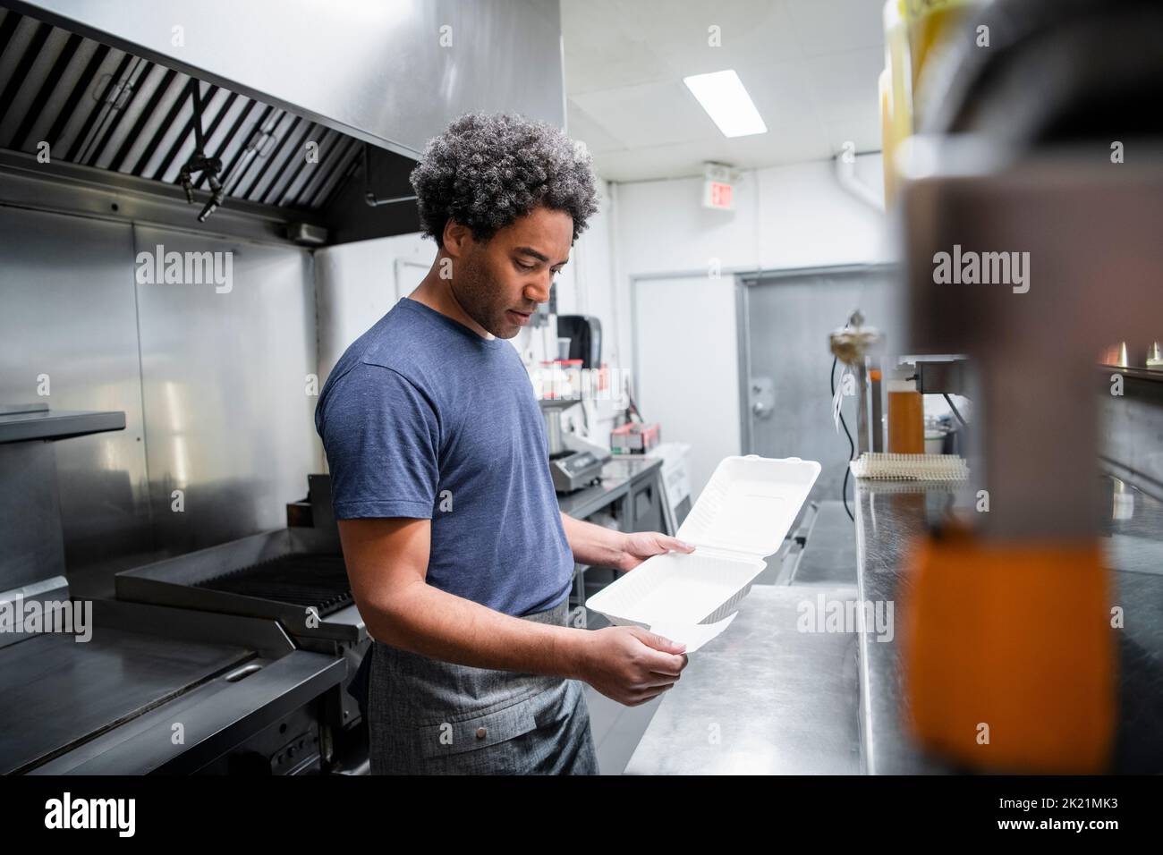 Male chef preparing takeout order in cafe kitchen Stock Photo - Alamy
