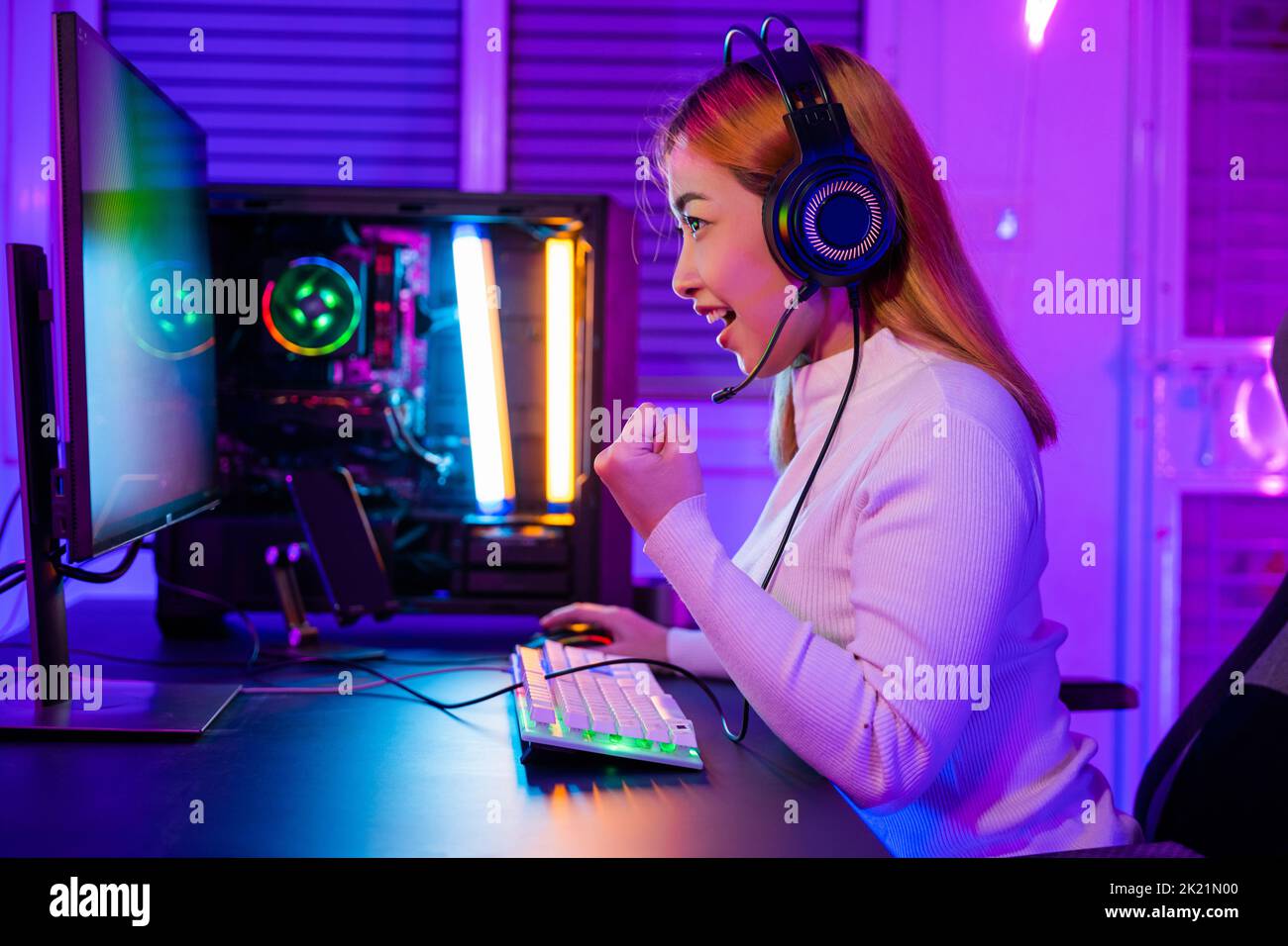 Winning Victory. Asian gamer playing online video game excited on ...