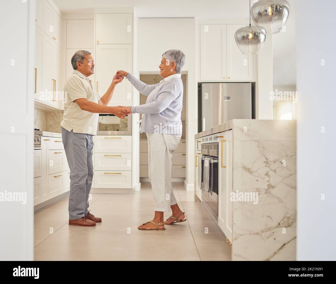 Mature couple dancing at home together for love, relax and romantic fun ...