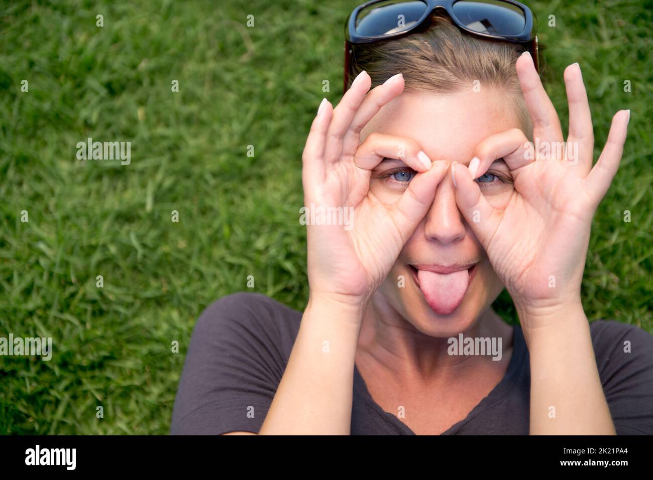 Blllrrrrr. a young woman pulling a silly face while lying down on the ...