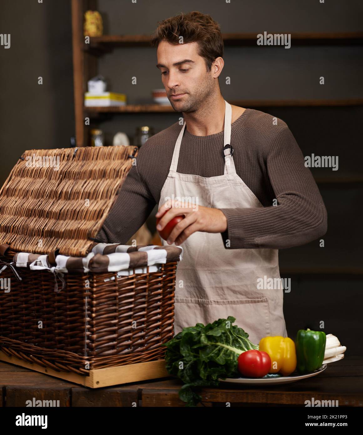 Unpacking his fresh veggies. a young man packing vegetables into a ...