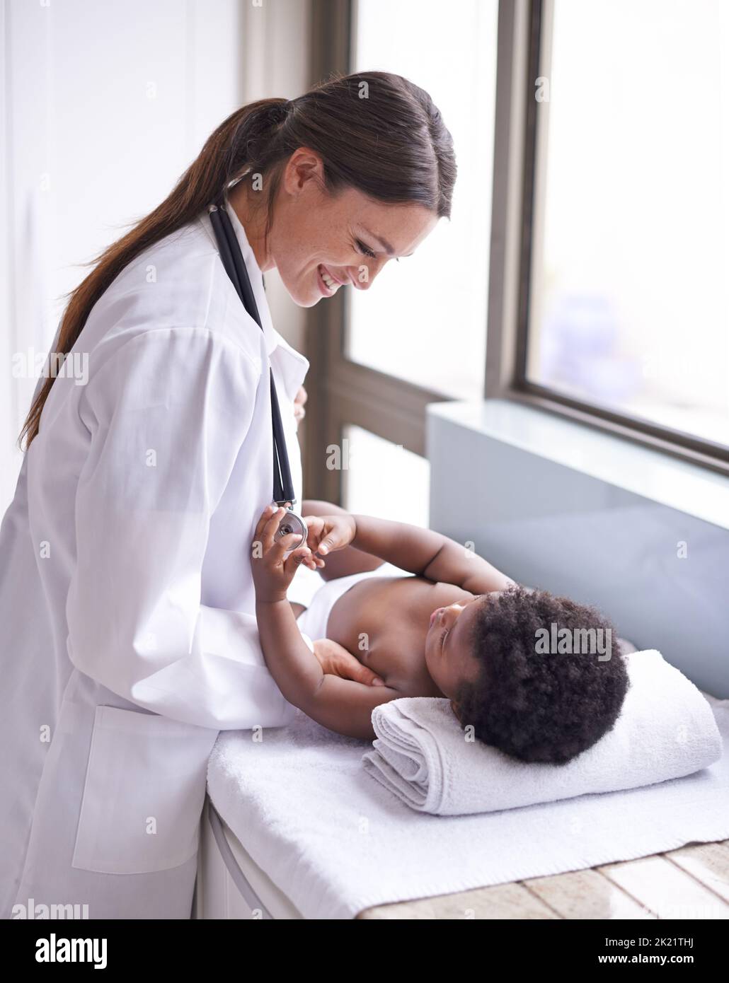 Just in for a routine pediatric checkup. a female pediatrician doing a ...