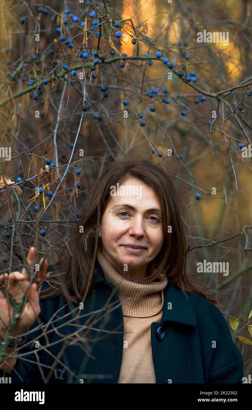 woman female model with dark hair next to a thorn bush looks at the ...