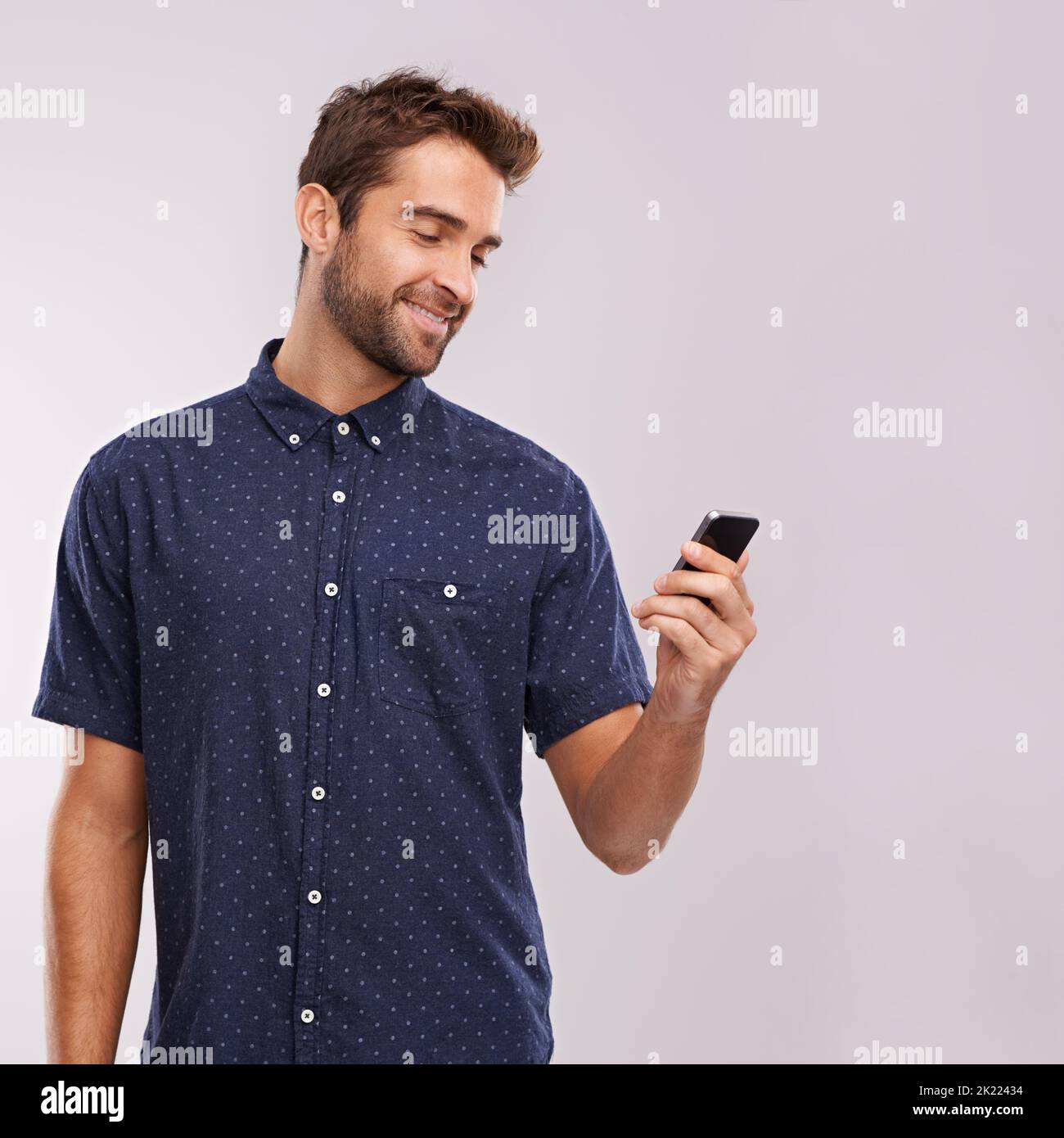 Receiving some good news. A handsome casually dressed man smiling as he ...