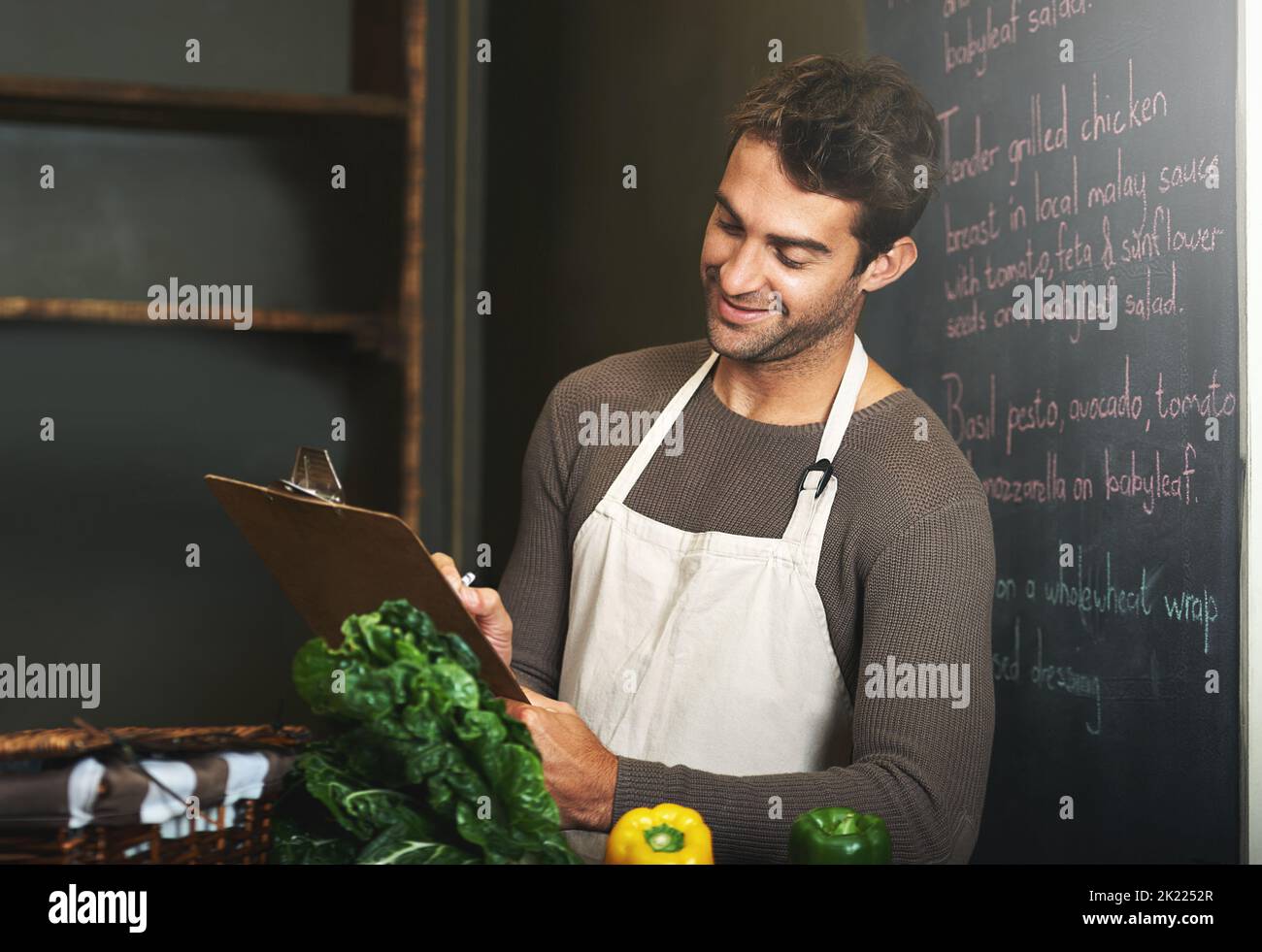 Checking his grocery list. A young man writing down something on a ...