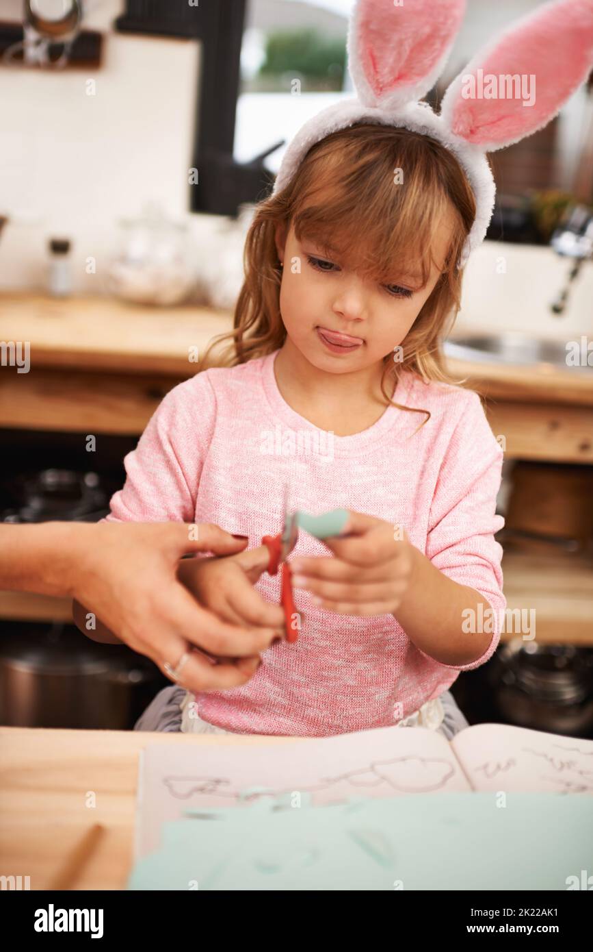 A helping hand. a little girl being helped with cutting Stock Photo - Alamy