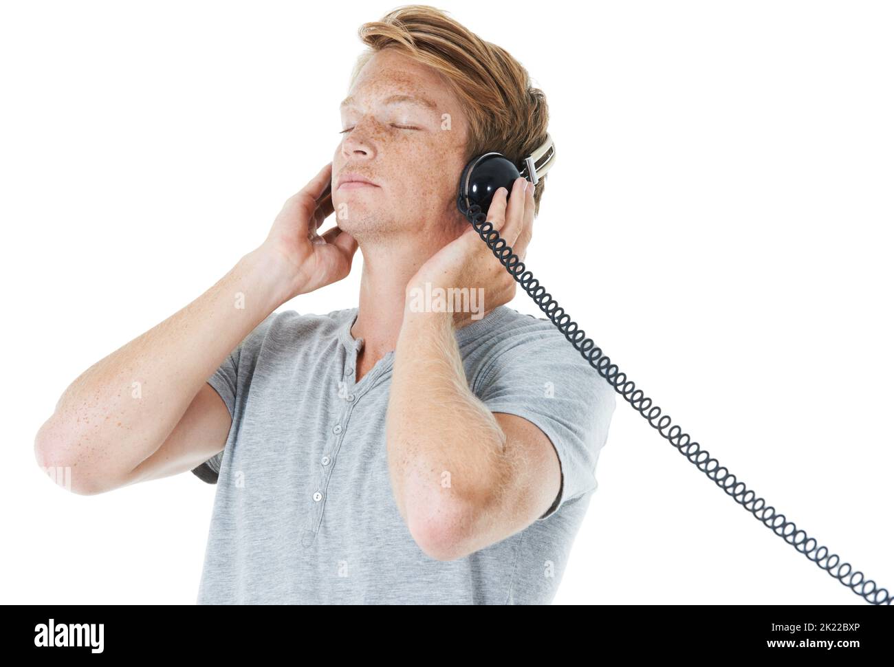 Mesmerized by the music. A handsome young red-headed man listening to ...