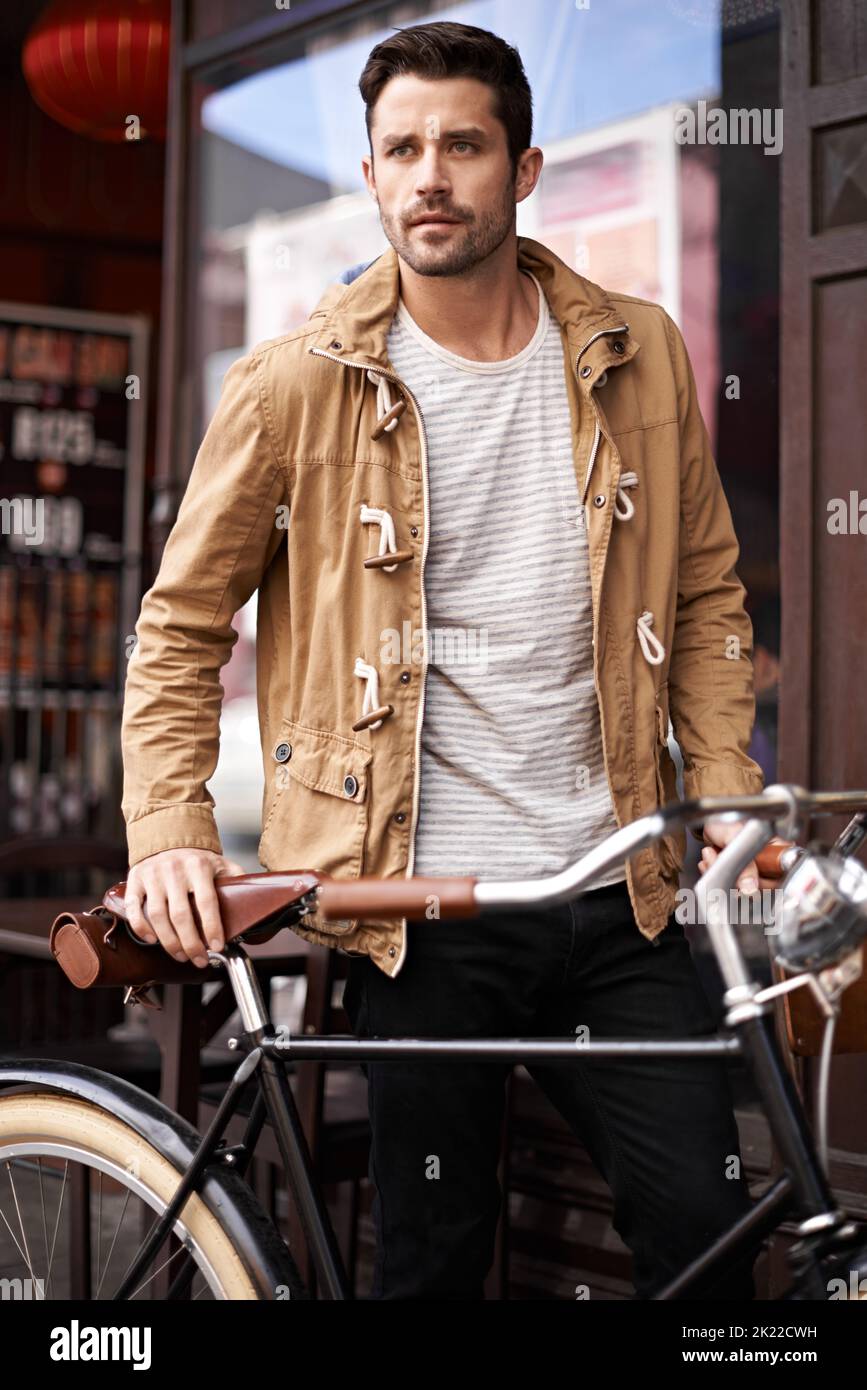 Time for a cycle. a fashionable young man holding a bicycle Stock Photo ...