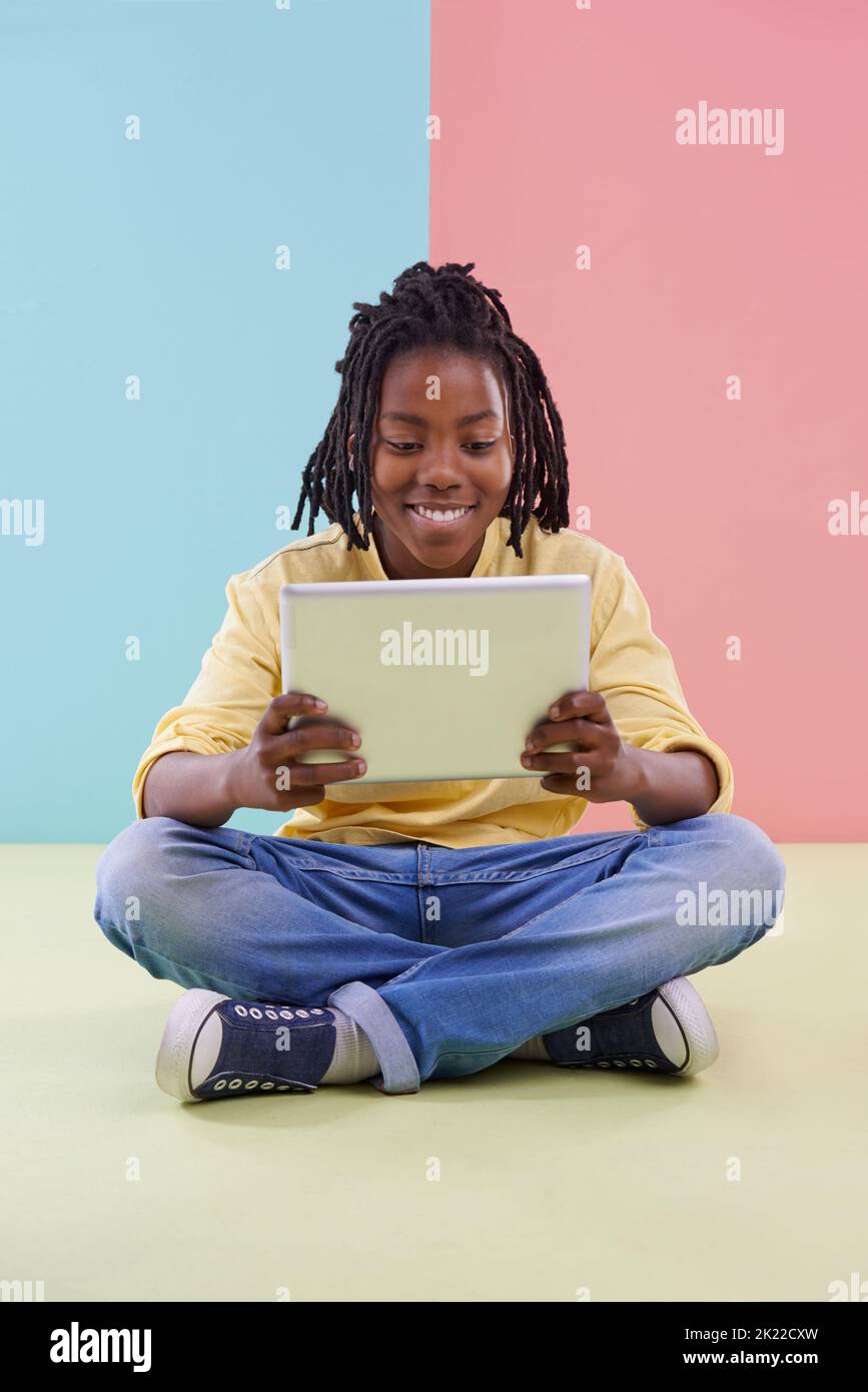 This tablet rocks. a young boy using a digital tablet while sitting on ...