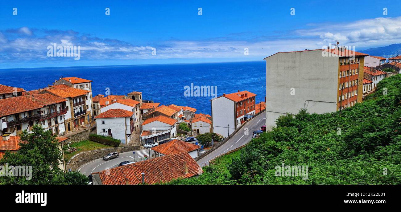 A high angle shot of rural houses and greenery against a blue sea Stock ...