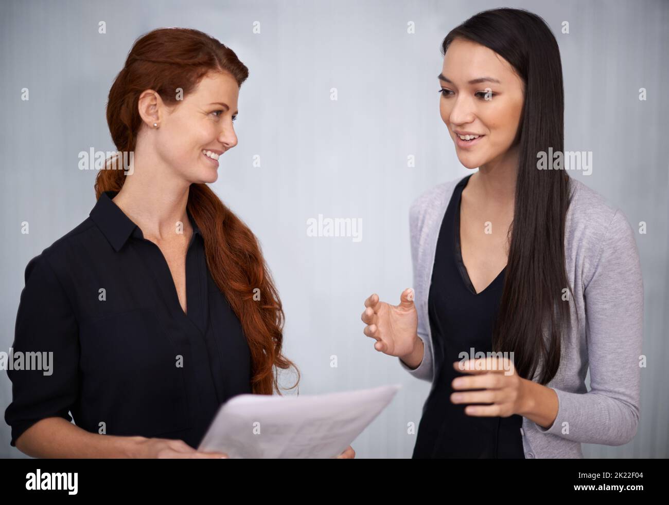 Heres my idea. two work colleagues having a discussion over a document ...