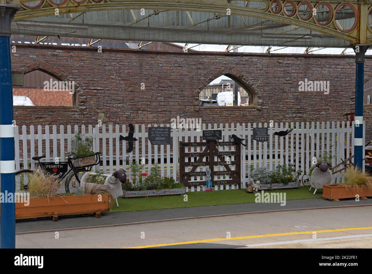 A display of flowers and sheep flower pots with a Welcome to Cumbria ...