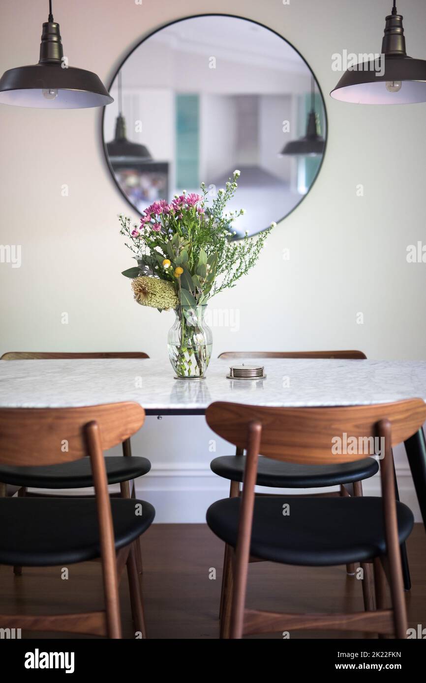 A vertical shot of a decorative vase with a floral bouquet on an empty ...
