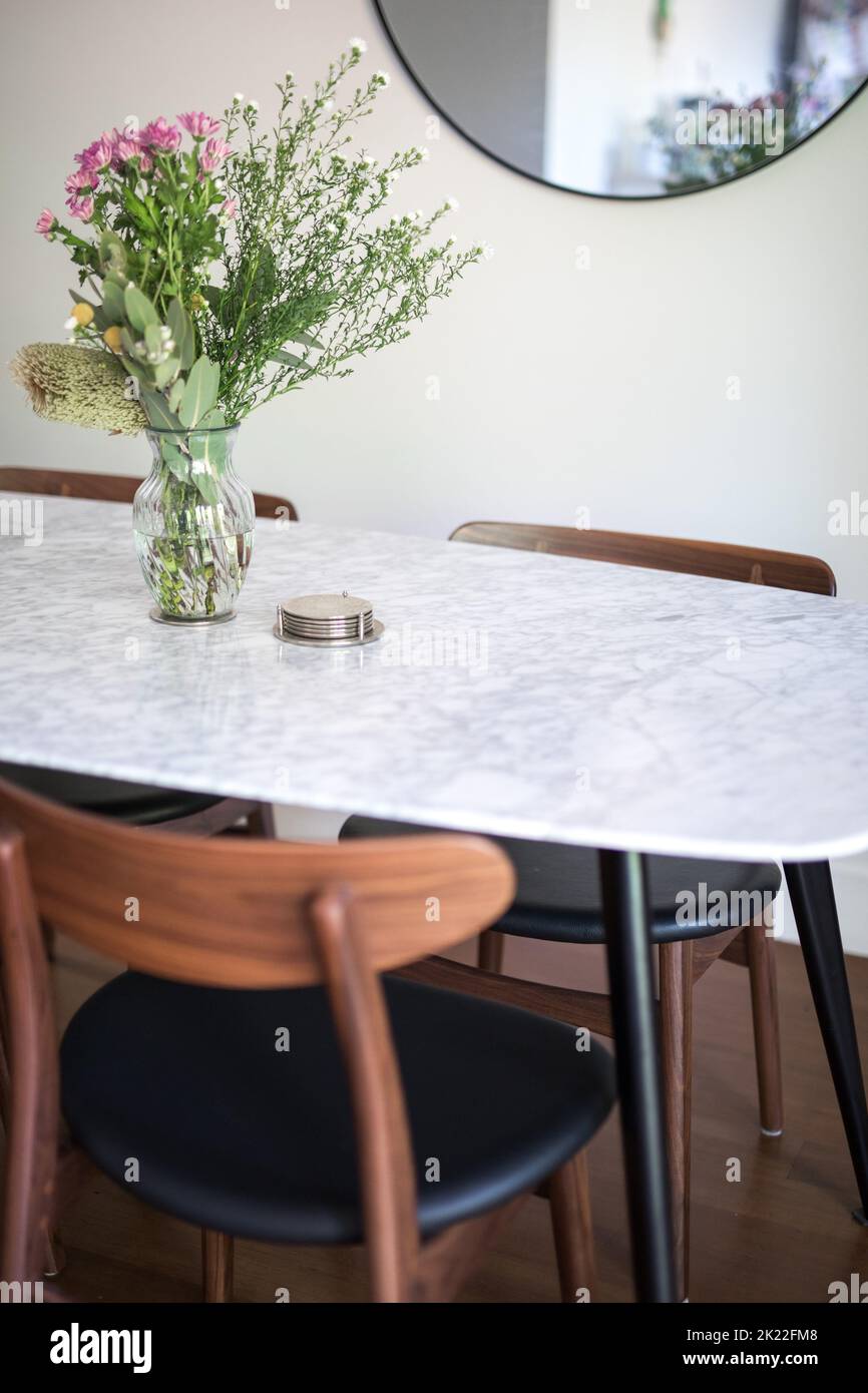 A vertical shot of a decorative vase with a floral bouquet on an empty ...