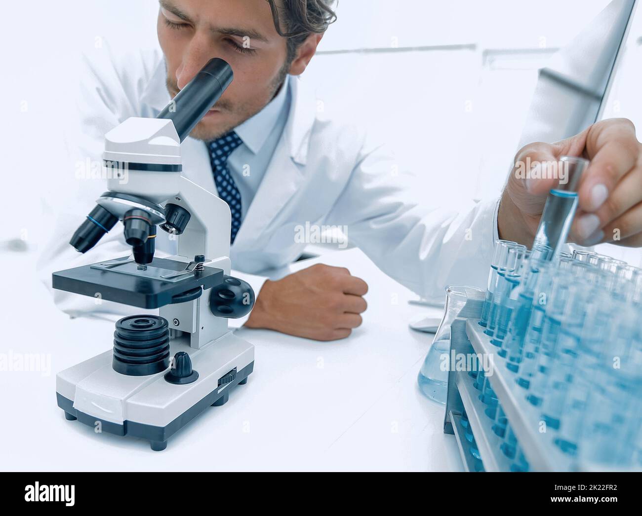 Chemist looking at test-tubes with blue liquids Stock Photo - Alamy
