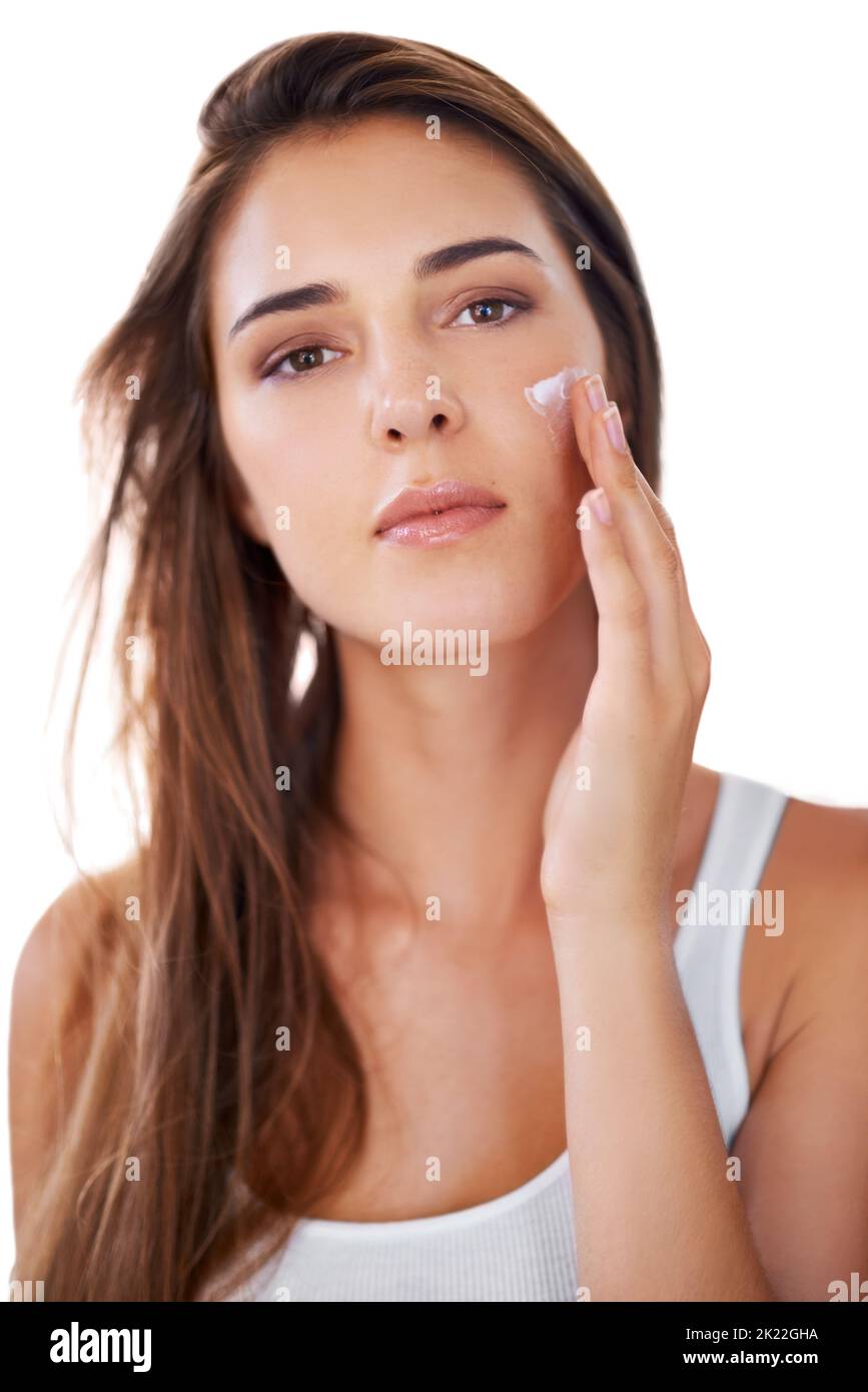 Simply perfect skin. a beautiful woman applying moisturizer to her face ...
