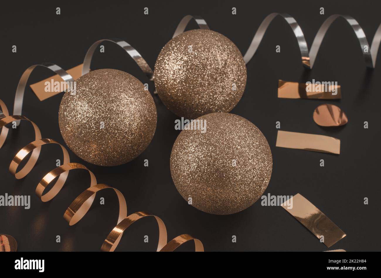 Christmas balls, streamer and sequins on a black background. Gold ...