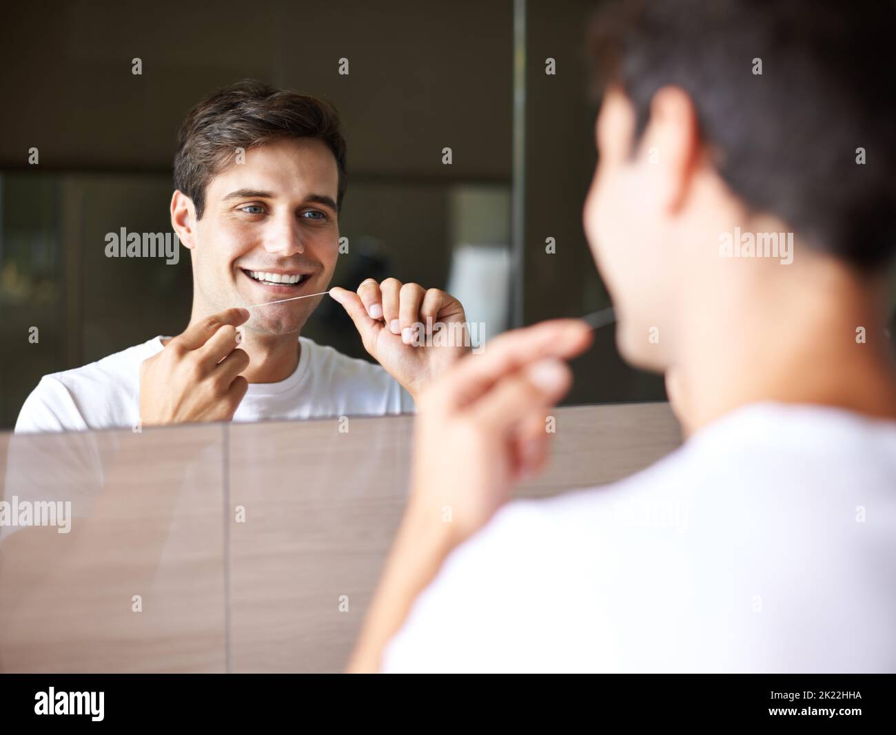 Good dental hygiene makes for strong teeth. a young man flossing his ...