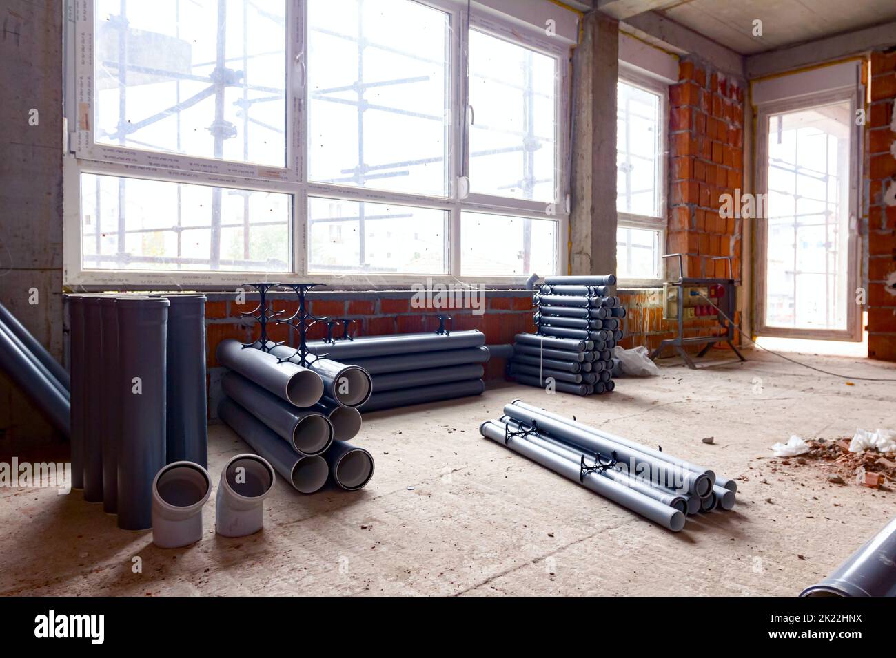 Arranged new grey plumbing sewer pipes are laid down on the floor ...