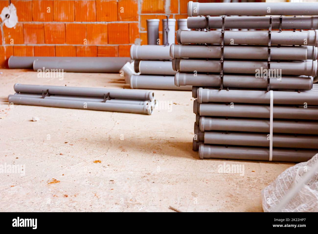 Arranged new grey plumbing sewer pipes are laid down on the floor ...