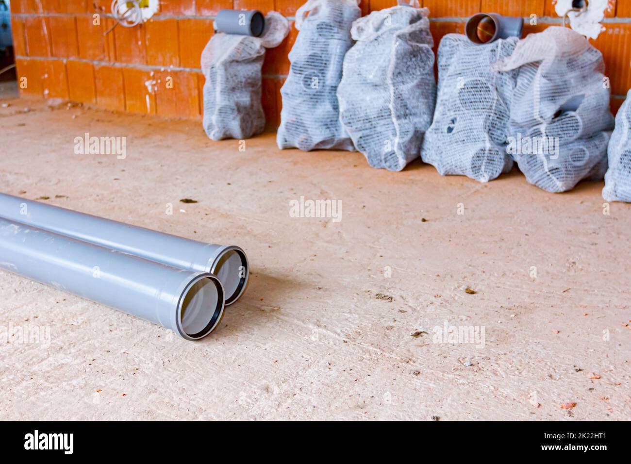 Stack of arranged parts of new grey plumbing sewer pipes elbows placed ...