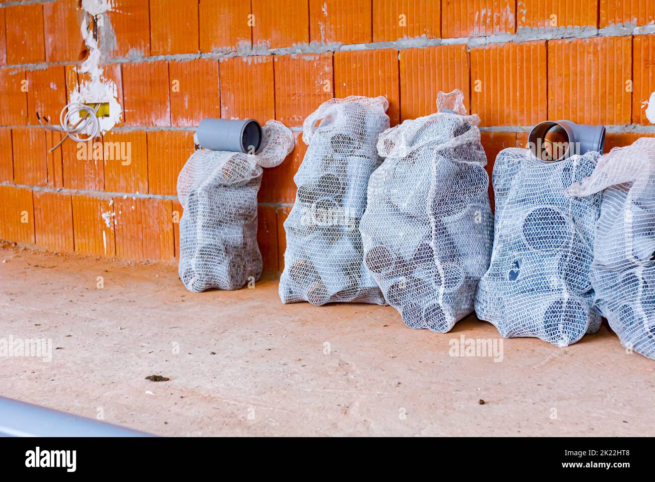 Stack of arranged parts of new grey plumbing sewer pipes elbows placed ...