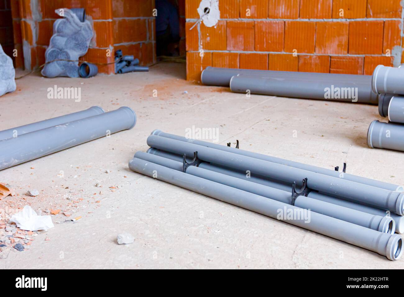A lot of new grey plumbing sewer pipes are laid down on the floor ...