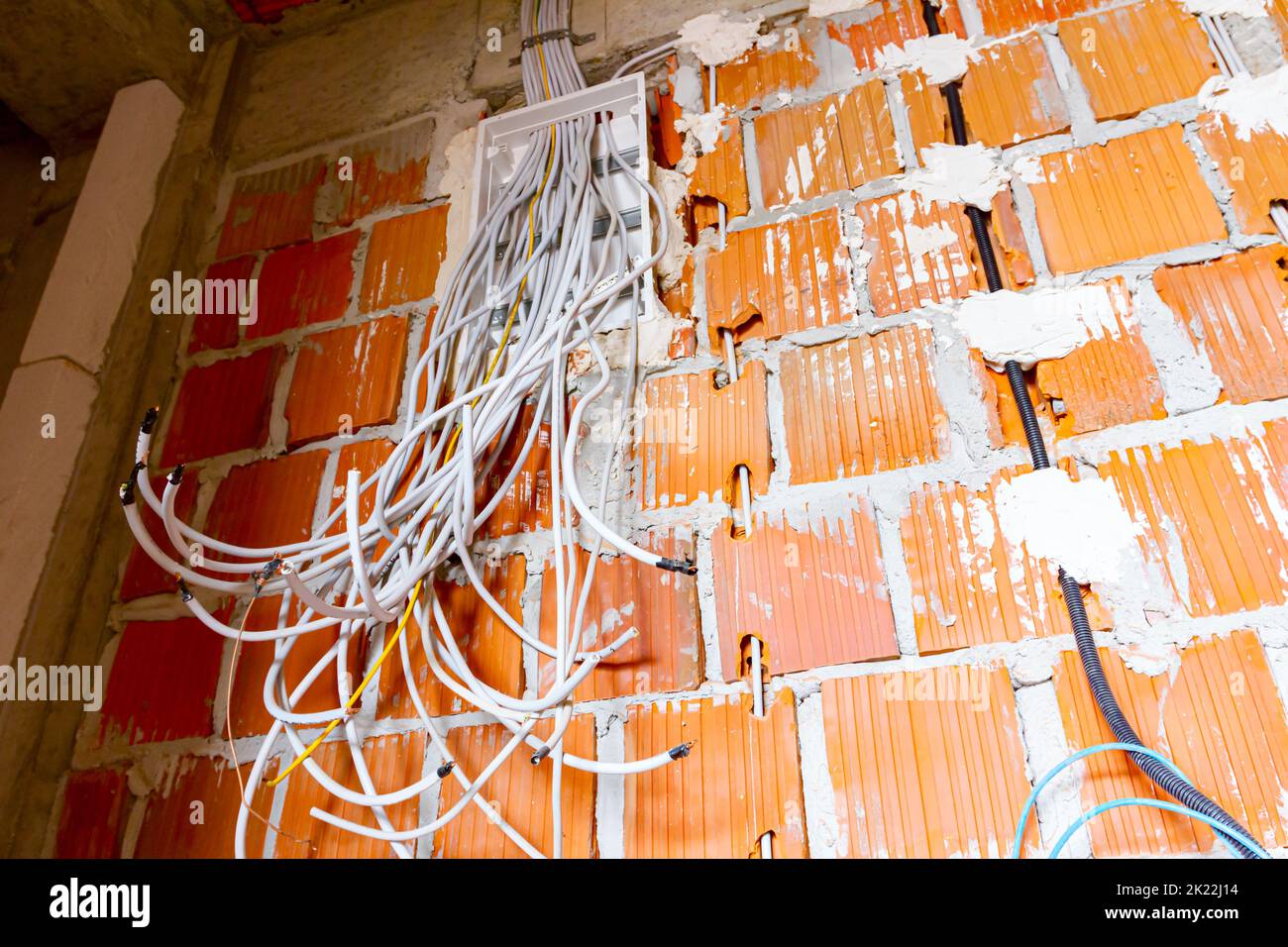 Bundle of various cables hang from a plastic fuse box mounted on the ...