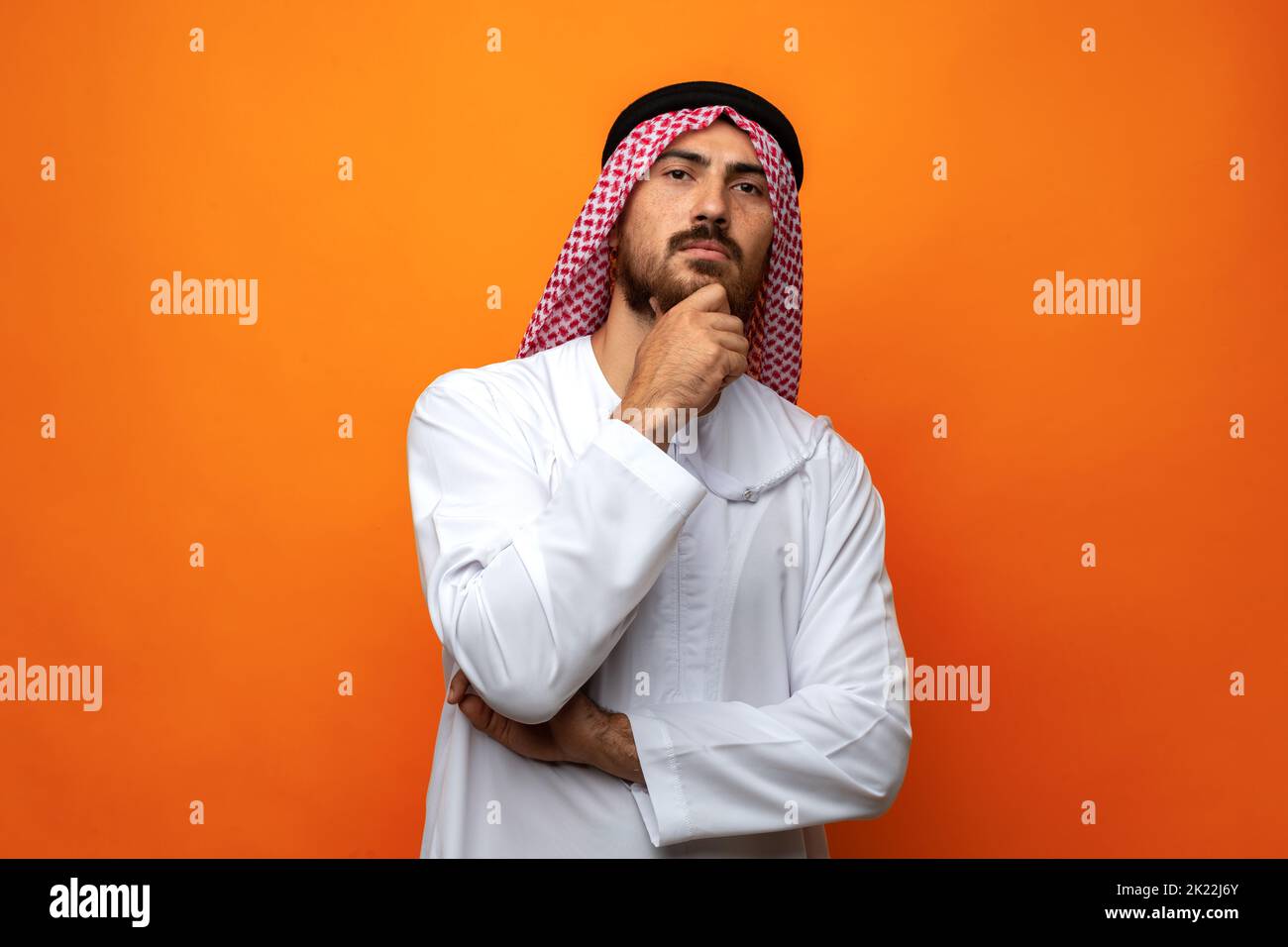 Young arab man wearing traditional clothes thinking about something ...