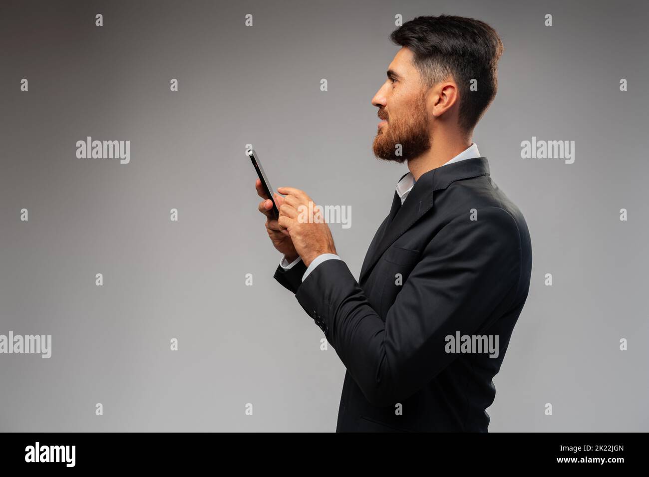 Young businessman using mobile phone in studio Stock Photo - Alamy