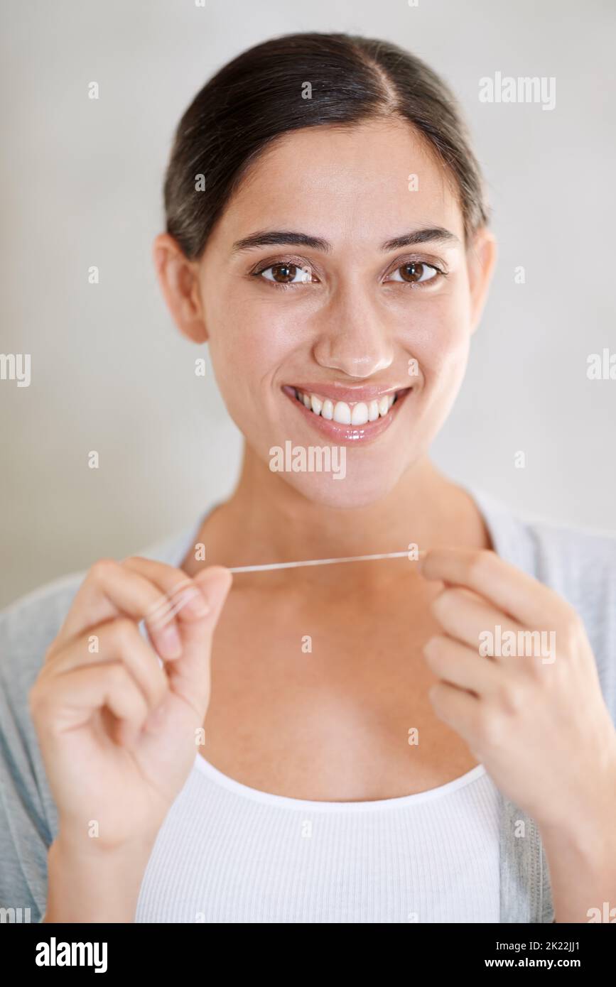 Regular flossing keeps my smile perfect. Portrait of an attractive ...