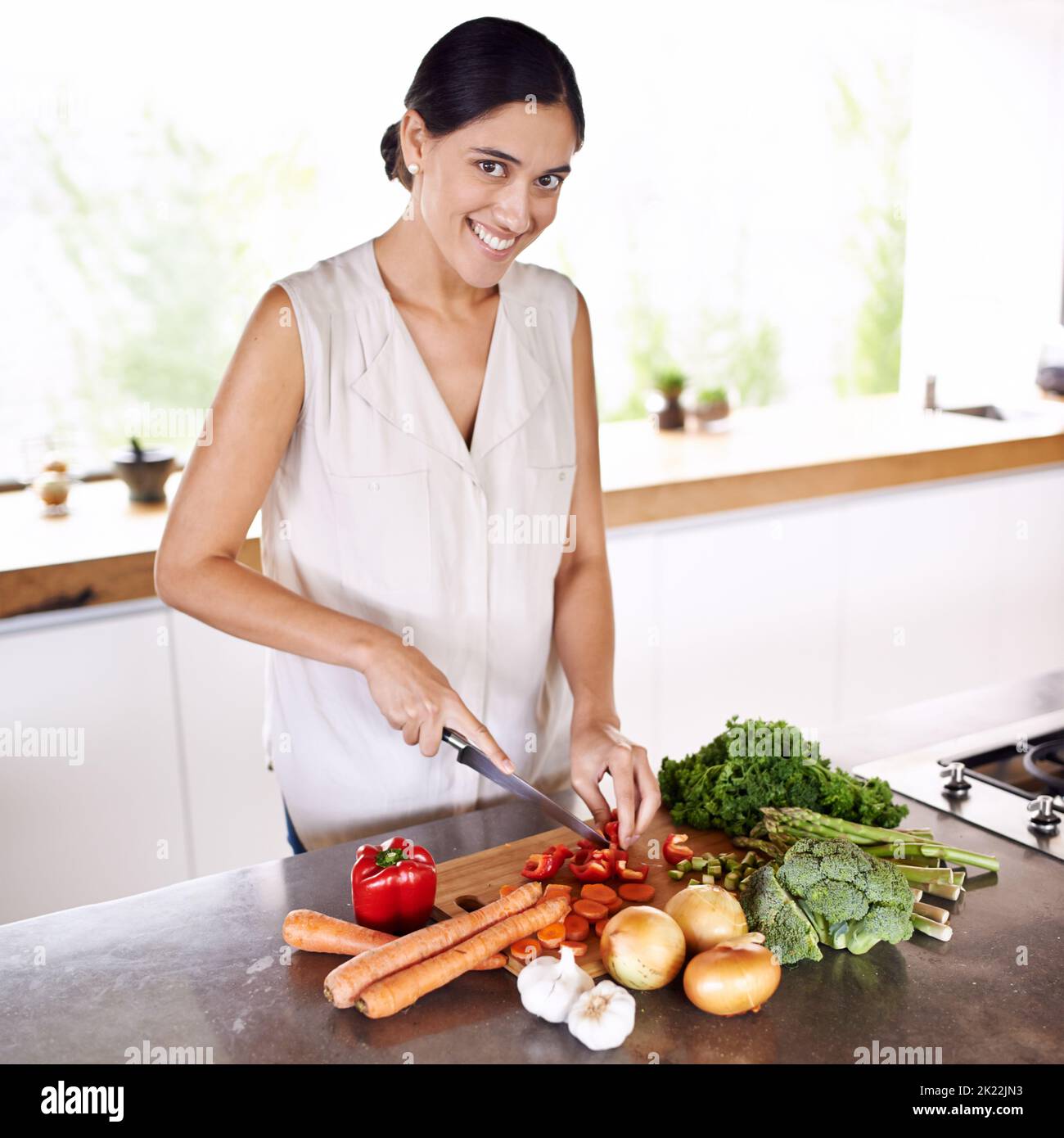 Making my famous vegetable soup. Portrait of a woman chopping ...