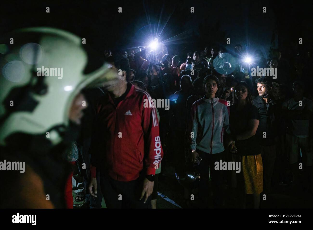 Kathmandu, Nepal. 21st Sep, 2022. People look on as firefighters work ...