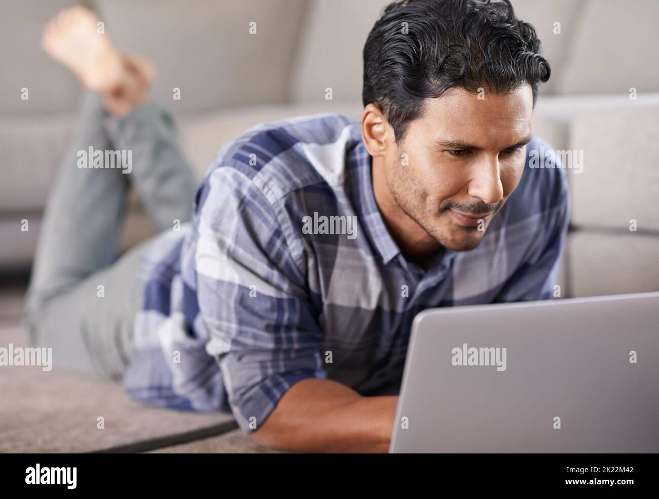Hes deeply immersed in the world wide web. A young man using his laptop ...