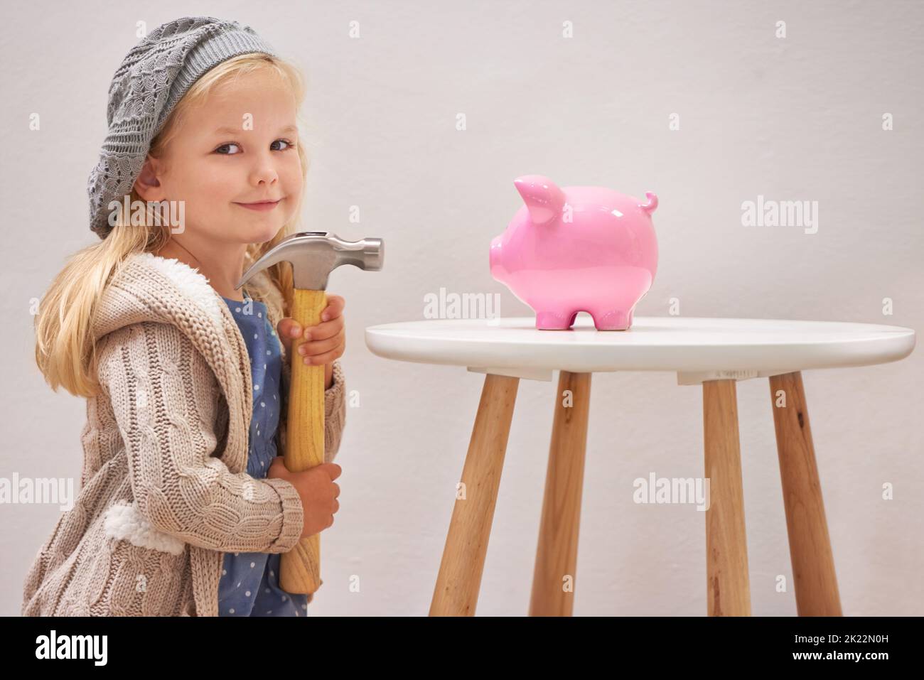 To break or not to break. A little girl standing in front of her piggy ...