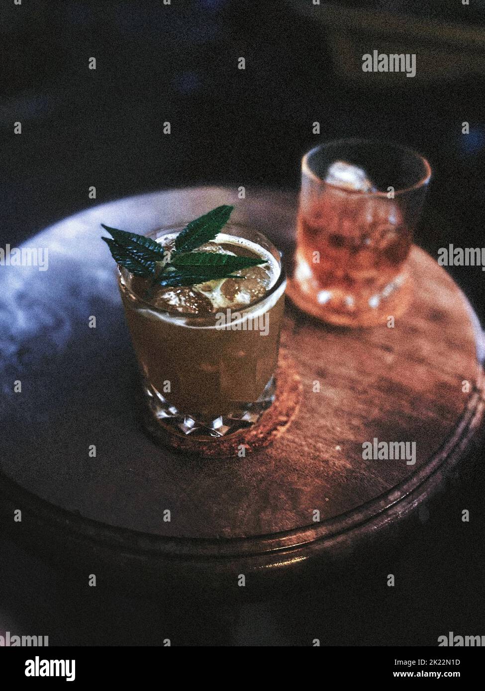 A closeup of a cocktail on a wooden round table Stock Photo - Alamy