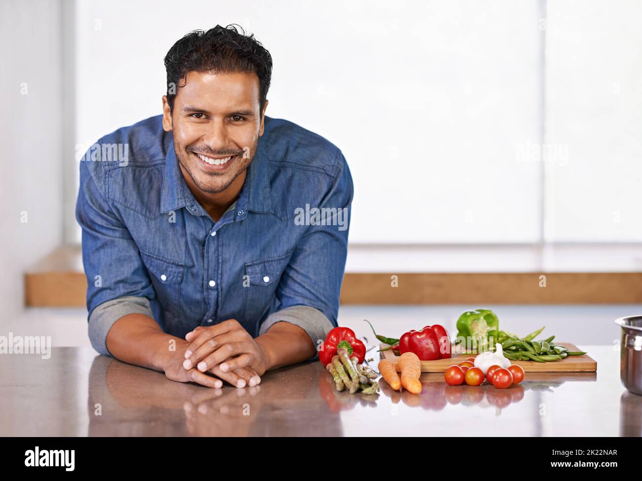 Dinners going to be great. A happy man leaning on his kitchen counter ...