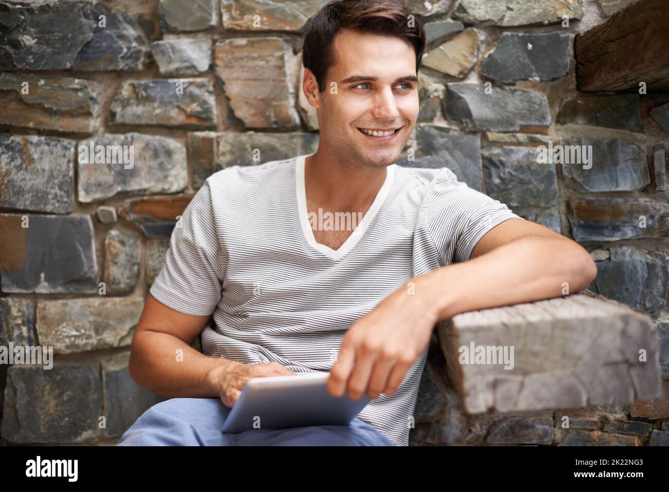 Say hello to summer. a man sitting outdoors while holding his digital ...
