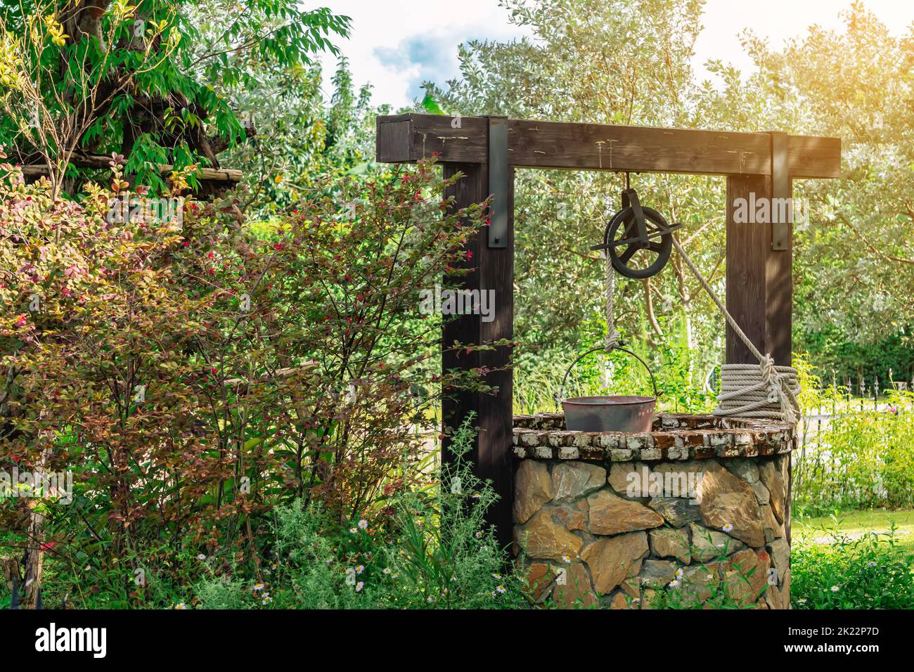 Beautiful artesian well made by stones and wheel pulley with metal ...