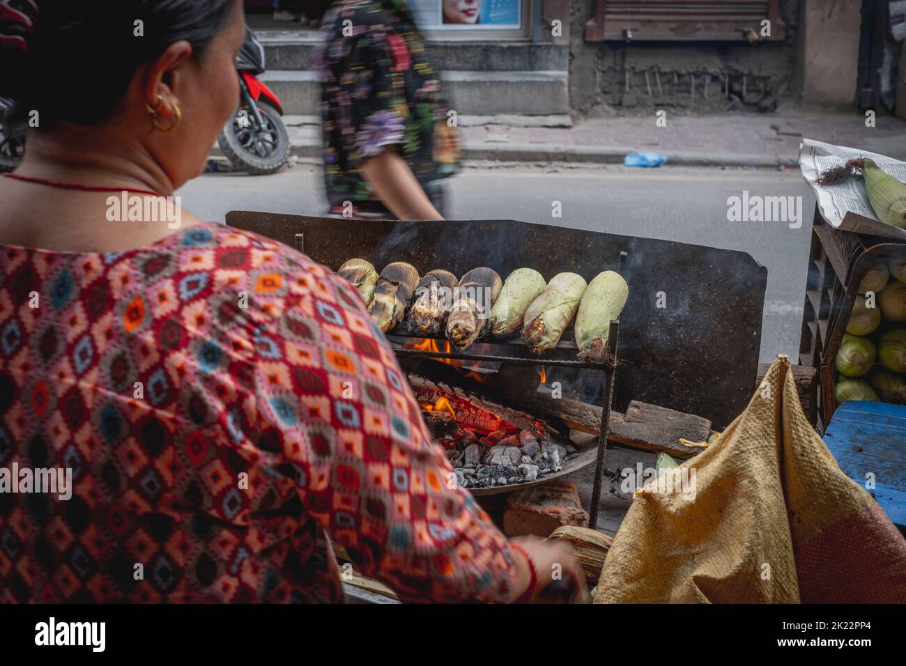 A lady cooking corn on the cob on the streets of Kathmandu, Nepal Stock ...