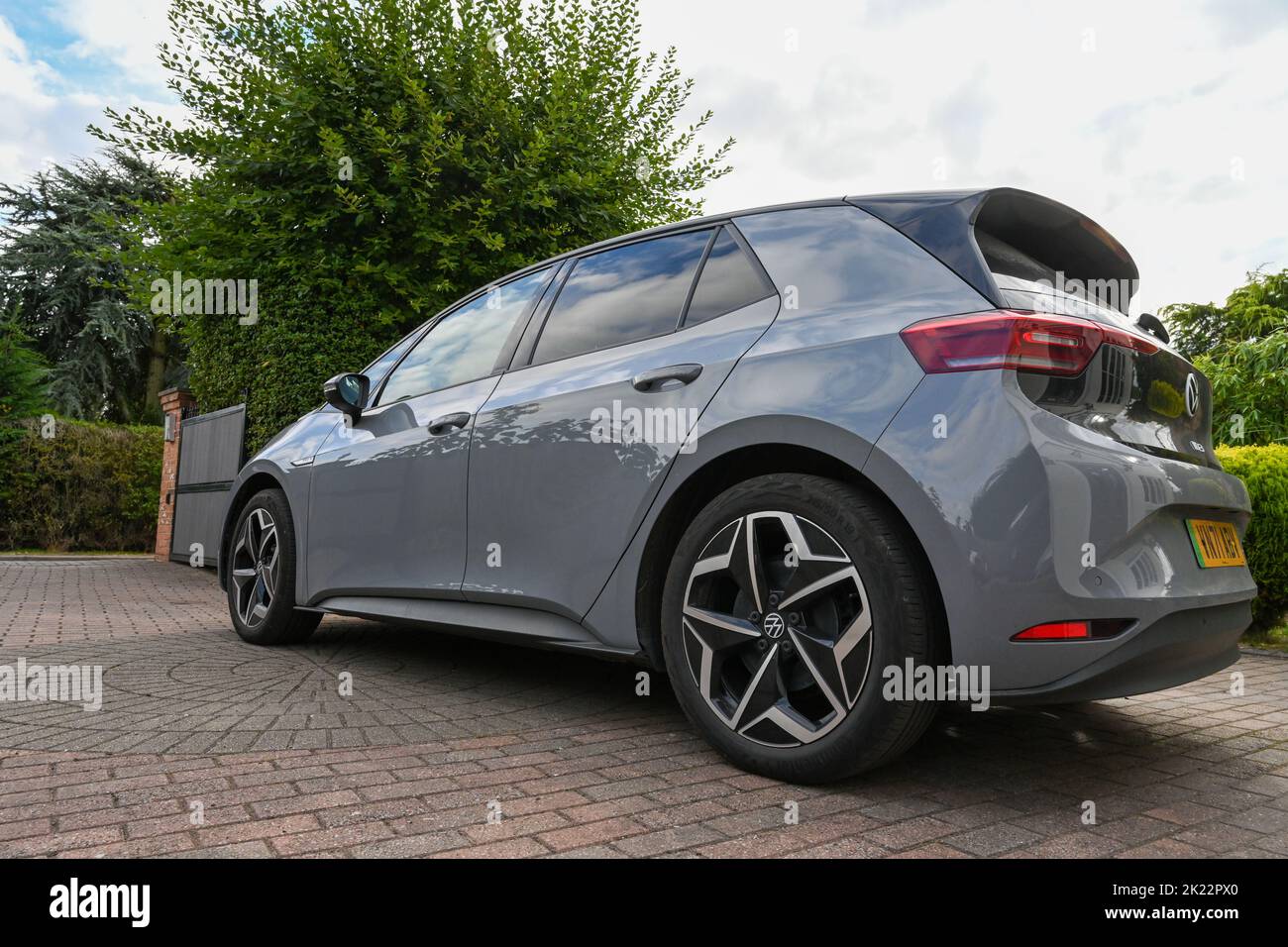 A view of an electric grey car leaving a rural property driveway with ...