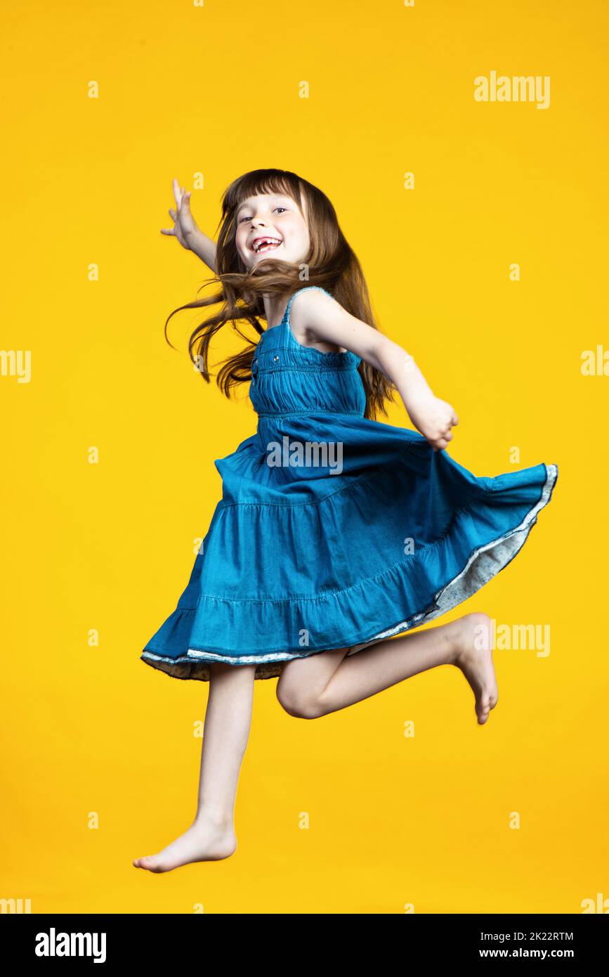 Funny preschooler girl joyfully jumps and smiles. The child is happy ...